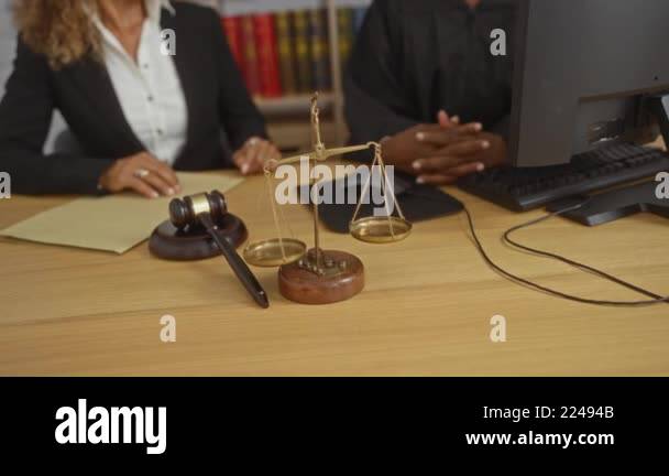 Lawyer and judge having discussion at desk with scales of justice and ...