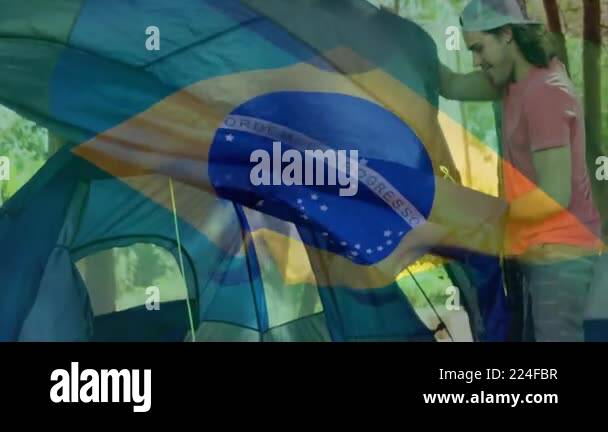 Brazilian flag animation over person setting up tent in forest. camping ...