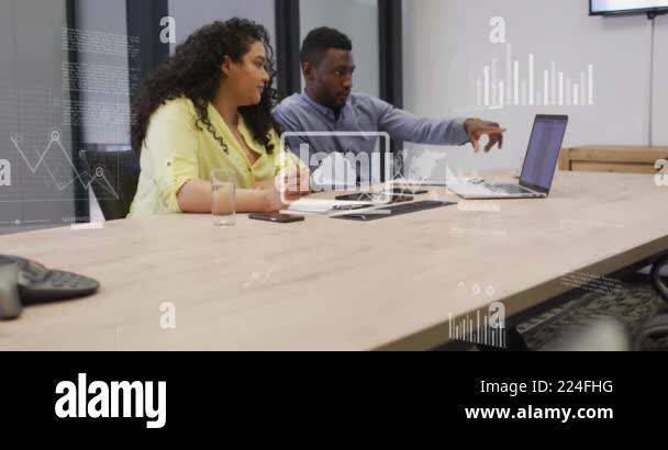 Discussing work at conference table, colleagues with business data ...