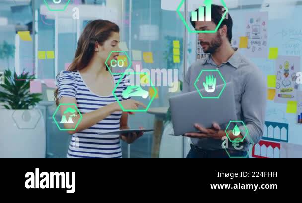 Holding laptop and tablet, colleagues discussing project with business ...