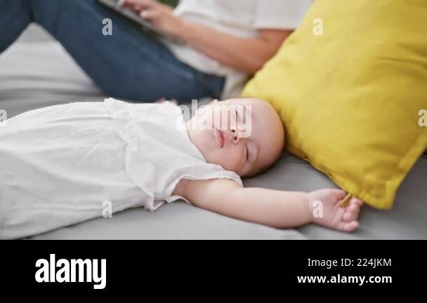 A loving mother multitasking with laptop in a relaxed home environment ...