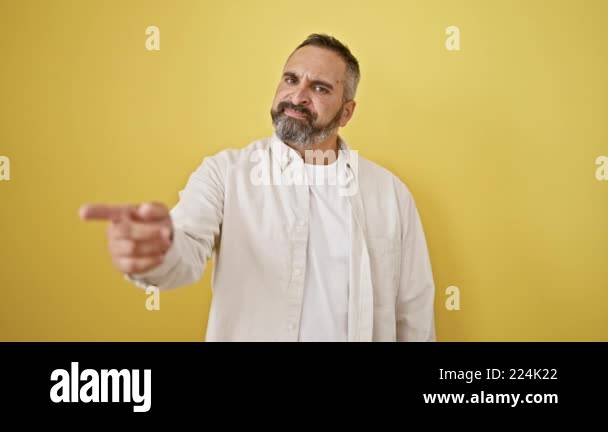 Mature bearded man with grey hair giving a thumbs down and disapproving ...