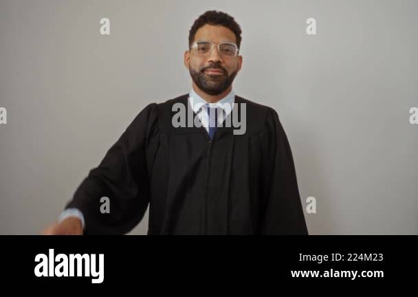 Judge gown, young hispanic man standing and showing peace with fingers ...