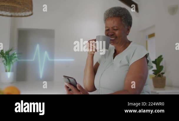 Animation of cardiograph with heart over senior biracial woman using ...