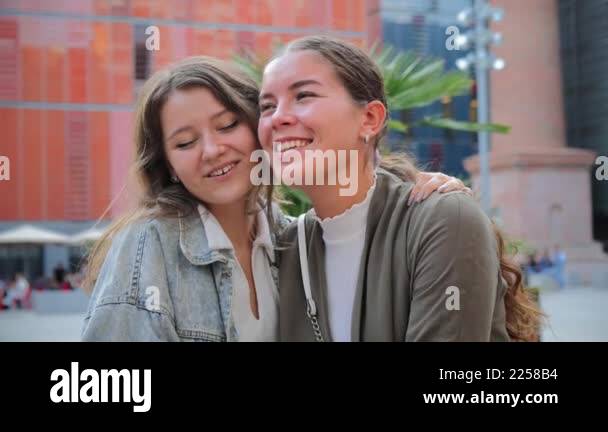 Joyful moment of affection between two female friends as one gives a ...
