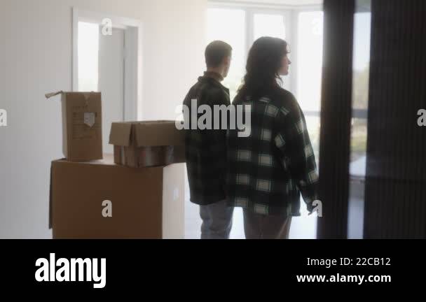 A joyful young American family, with a rear view of a couple hugging as ...