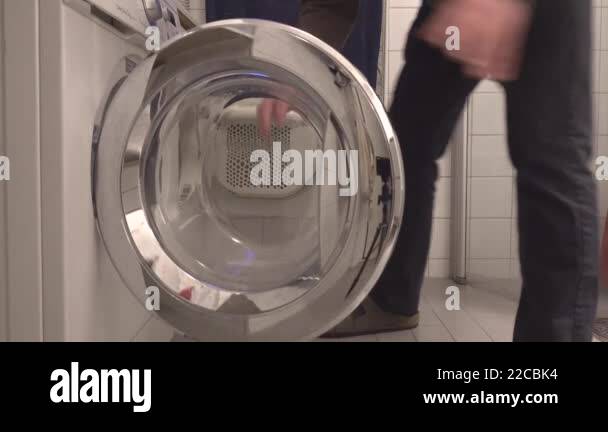 Stockholm, Sweden A man unloads a washing machine and loads a dryer in ...