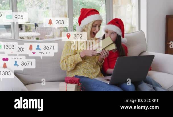Social media engagement animation over women in Santa hats using laptop ...