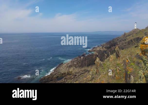 Iconic Lighthouse on Rocky Cliff Overlooking the Vast Blue Ocean under ...
