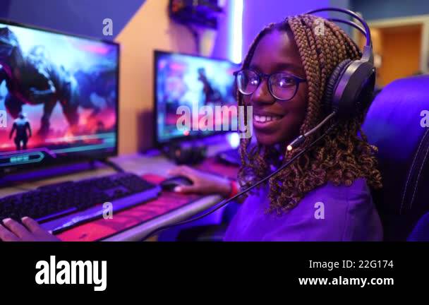 Confident young woman wearing gaming headset showing thumbs up while ...