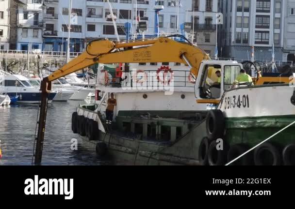 Busy Day at the Harbor: Maintenance Team Working on Yellow Crane Aboard ...