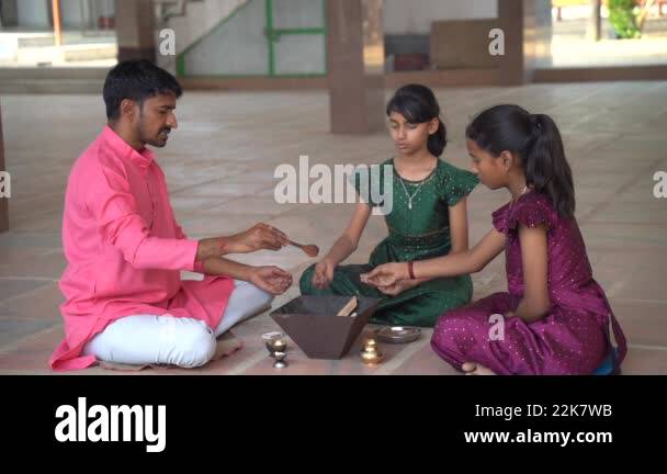 An Indian family in traditional attire performs a Yagya or Havan, led ...