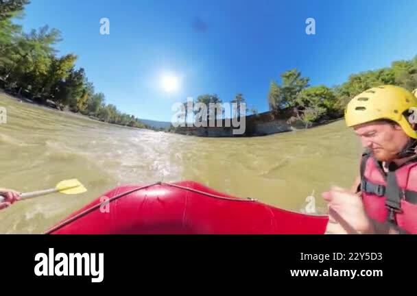 A low-angle shot from the front of a rafting boat, capturing two ...