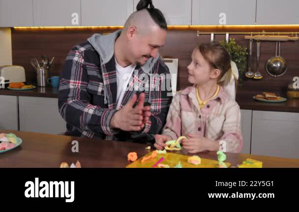 Positive handsome father and engrossed cute school age daughter ...