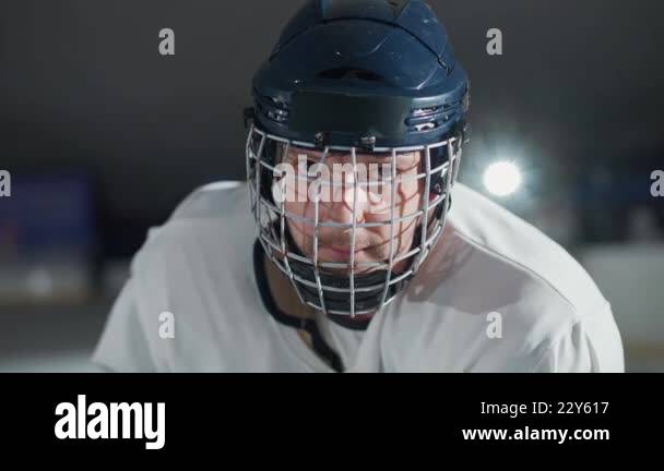 Handheld, portrait of a forward hockey player seriously looking at the ...