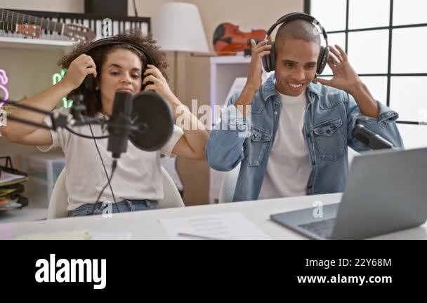 Smiling musicians work together, wearing headphones and presenting news ...