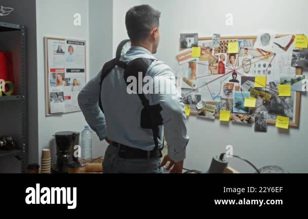 Hispanic detective man standing in an indoor crime investigation office ...
