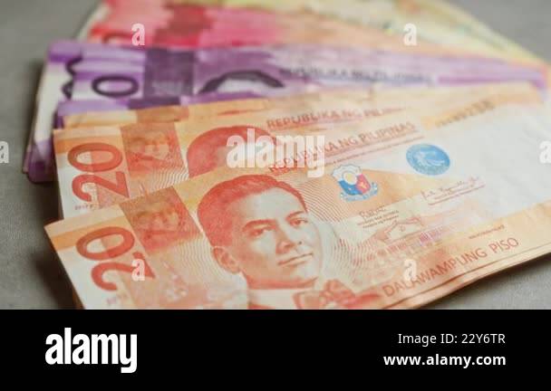 Philippine banknotes of various denominations spread out on a concrete ...