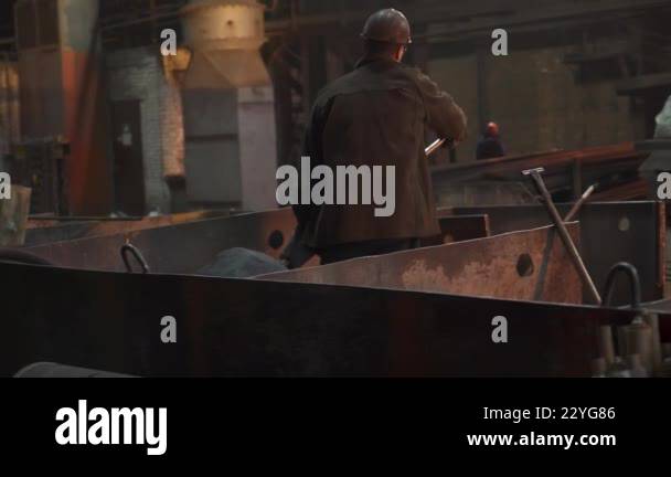 A skilled worker in an industrial setting, enthusiastically handling ...