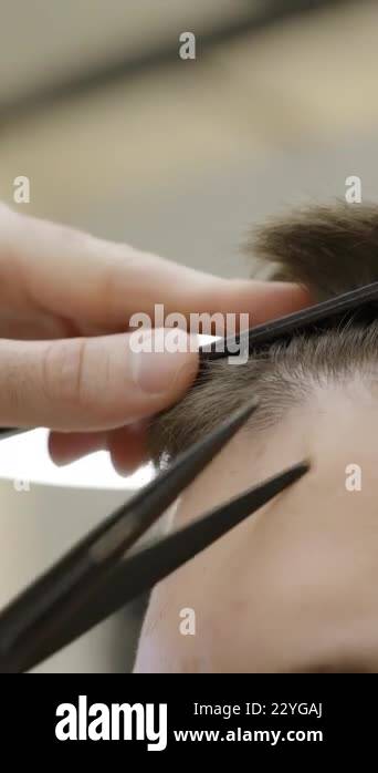 In a chic and modern salon setting, a skilled barber expertly styles a ...