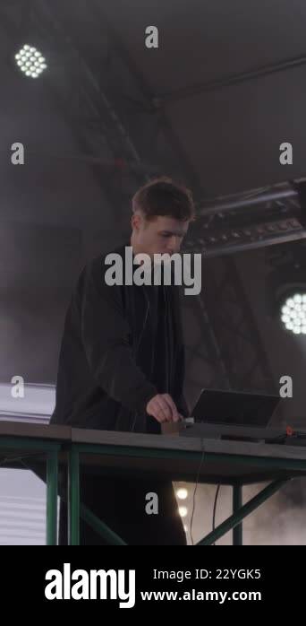 An artist showcases live electronic music performances on stage while ...