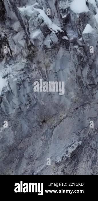 A stunning close up of a snowy mountains rocky face, magnificently ...