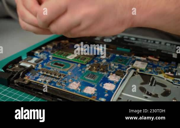 Father helping son apply thermal paste, carefully working on laptop ...