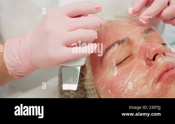 Woman receiving facial anti-aging mask treatment with precision. Female ...