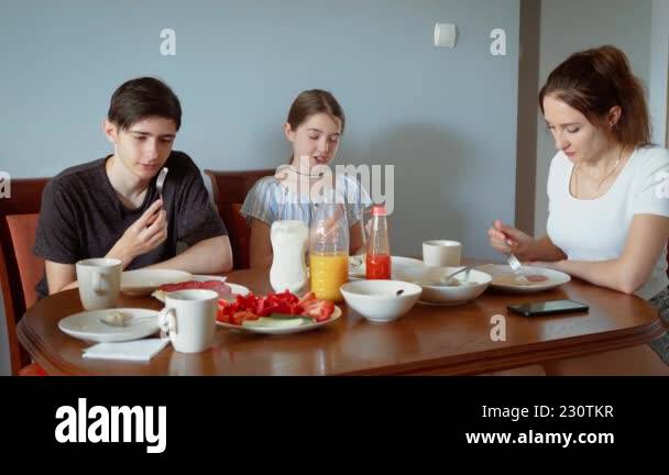 Family enjoying breakfast sharing peaceful morning moments. Mother son ...