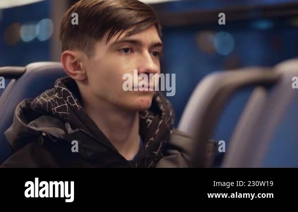 Tired boy traveling in bus at night, gazing forward with quiet ...