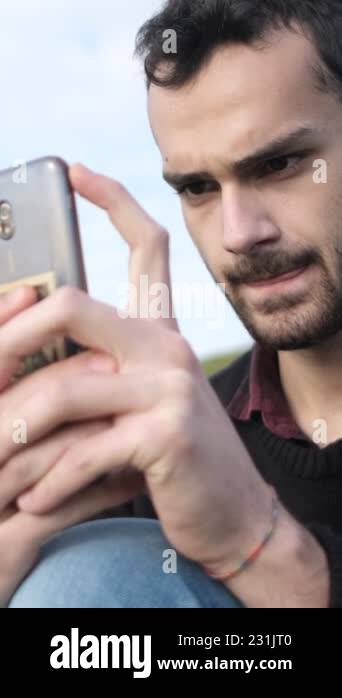Image of young people looking at their phones in the park, leisure time ...