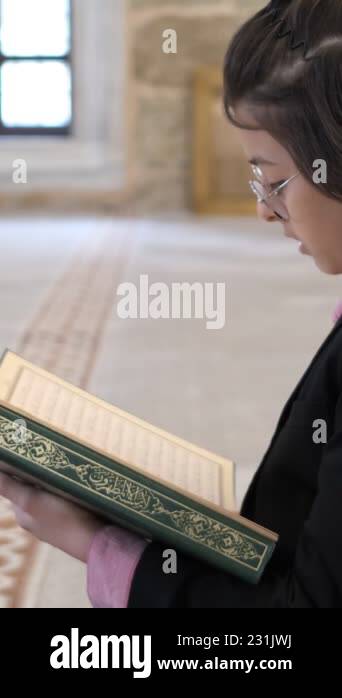 Little boy reciting quran in historical mosque, child with glasses ...