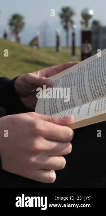 Image of lonely man reading novel on white bench in sunny day ...