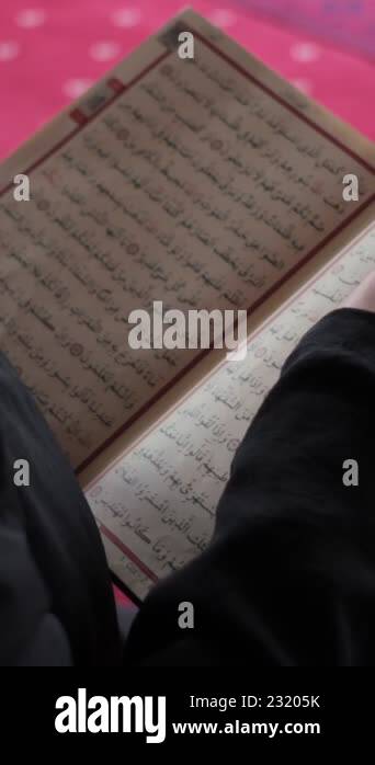Turning the pages of the Quran on the wooden lectern inside the mosque ...