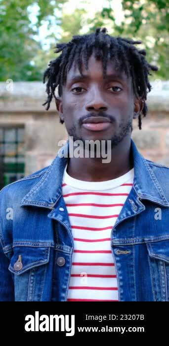 An african young man standing in an open field extends his hand by ... An african young man standing in an open field extends his hand by ...