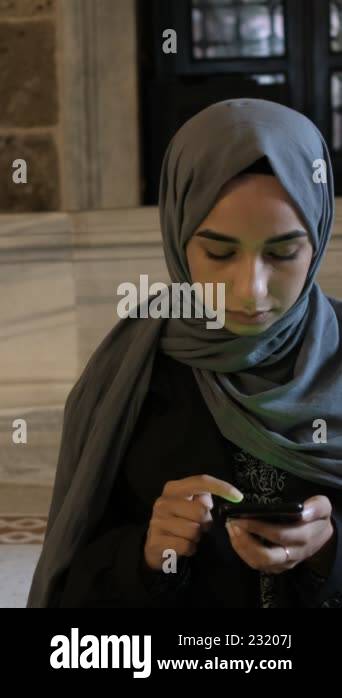Young muslim woman reading quran smartphone mosque, girl wearing hijab ...