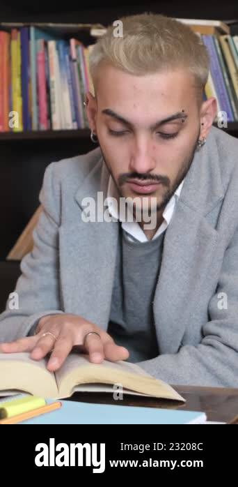 Concept of young man carefully reading a book with his back to the ...