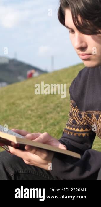 Image of lonely man reading a book on the grass, reading a novel on the ...