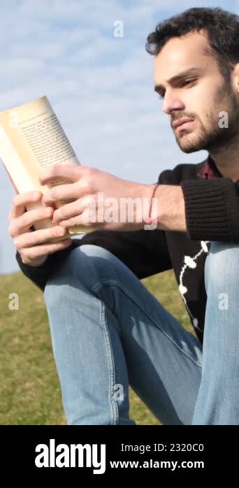 Image of lonely man perusing a book on the grass, reading a novel on ...