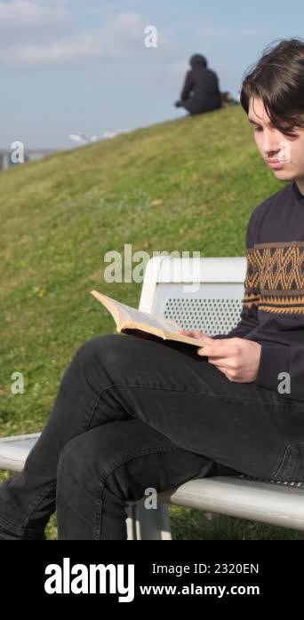 Image of lonely man reading a book on the grass, reading a novel on the ...