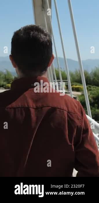 Young man walking across the bridge, front view of young man crossing ...