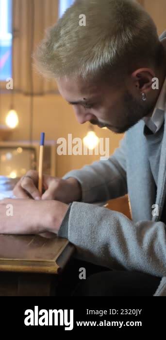 Young man taking notes with colored pencils, taking notes highlighters ...