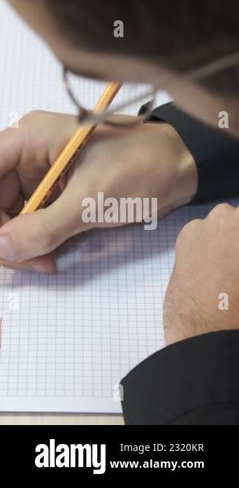 Student Geometry Table, man taking notes in the notebook with colored ...
