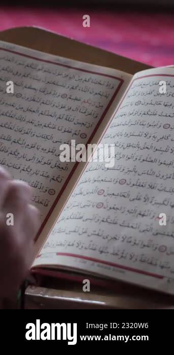 Turning the pages of the Quran on the wooden lectern inside the mosque ...
