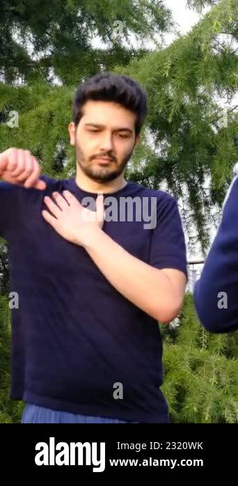 Three young men doing sports in the park by crossing their arms ...