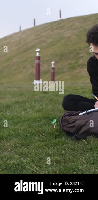Themed image of young man doing writing and reading on the lawn, a ...