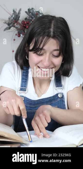 Smiling teenage girl reading fun books, student studying novels at her ...