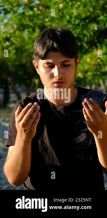 Young man worshiping outdoors, praying in the garden, worshiping in ...