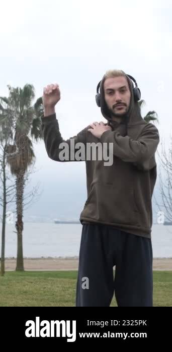 Alone man doing arm opening gesture in sport on the grass, doing ...