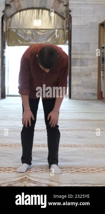 Muslim man praying in a mosque, bowing on his knees, performing ruku ...